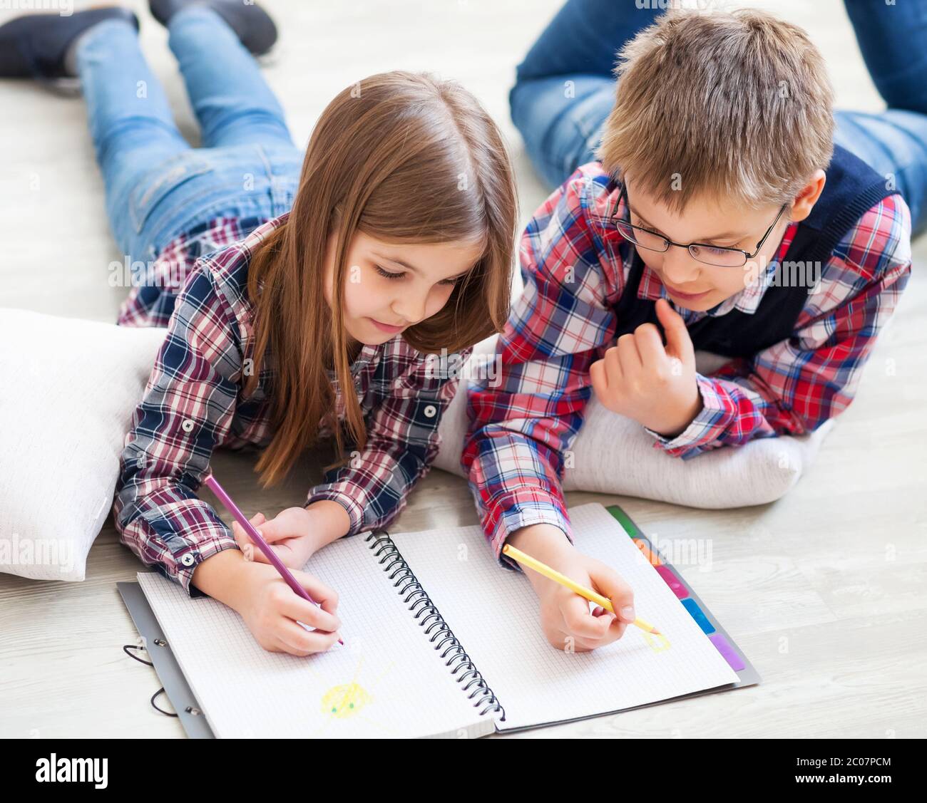 Two little kids drawing with crayons Stock Photo - Alamy
