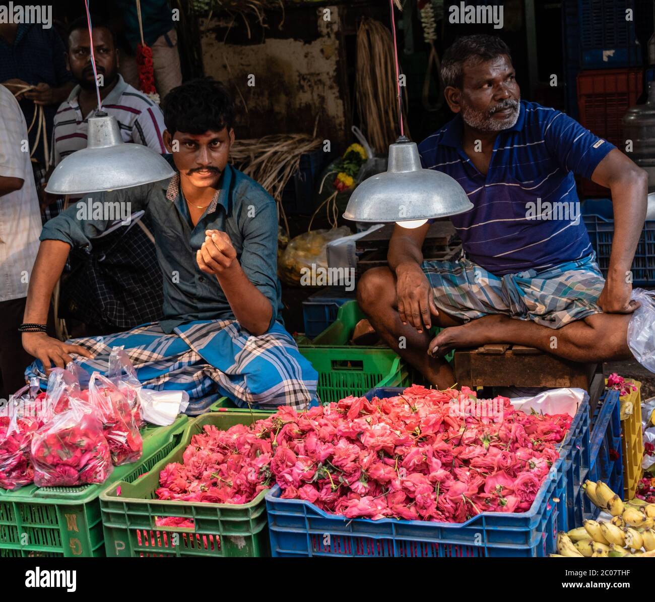 Chennai, Tamil Nadu, India - August 2018: Indian men selling pink roses at the Georgetown flower ...
