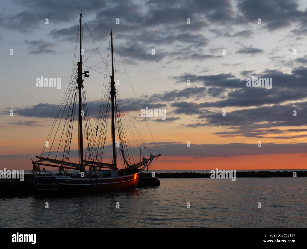 sunset with sailing vessel Stock Photo - Alamy
