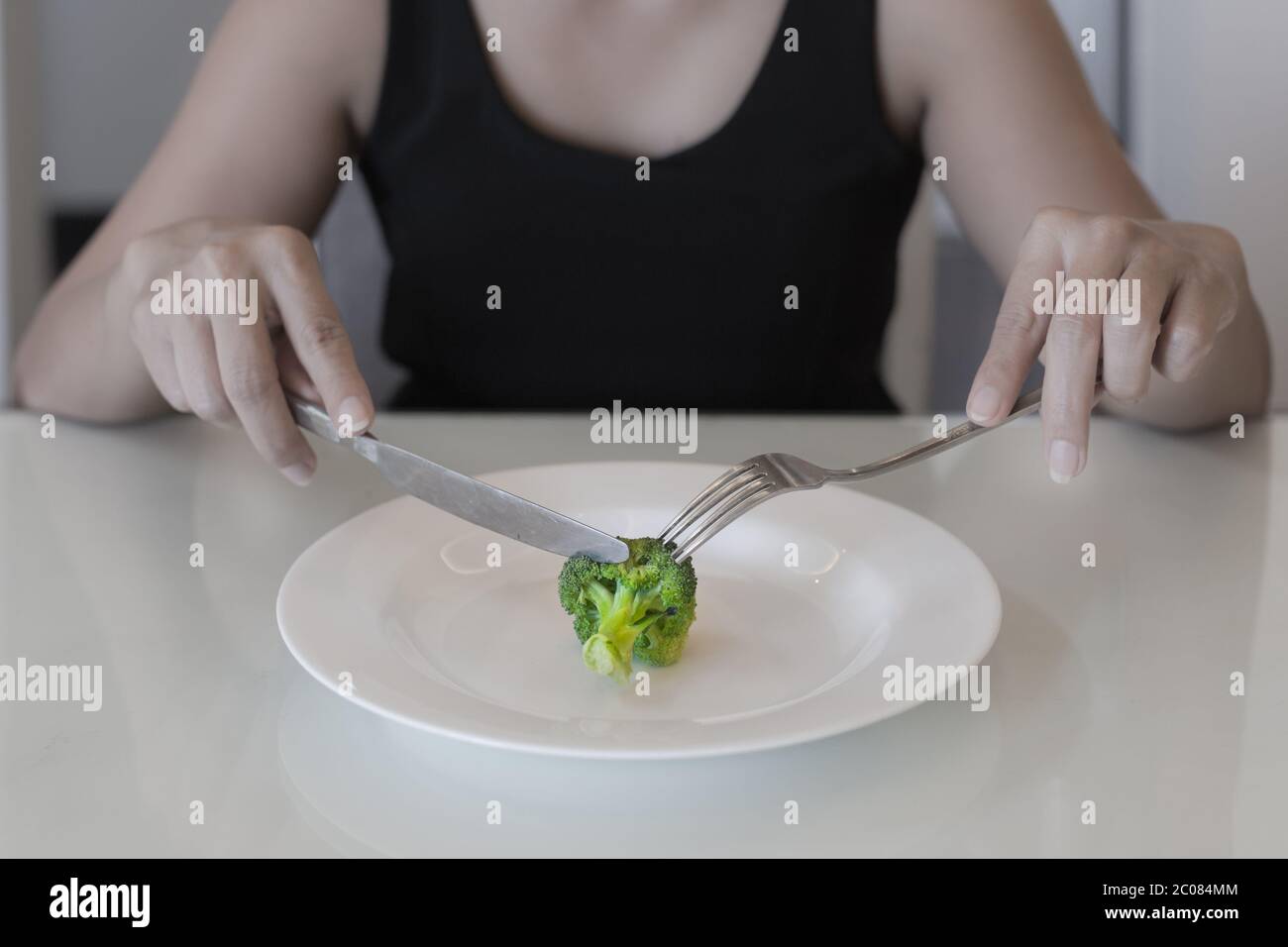 A woman eating a small portion of vegatables. Low calorie diet Stock ...