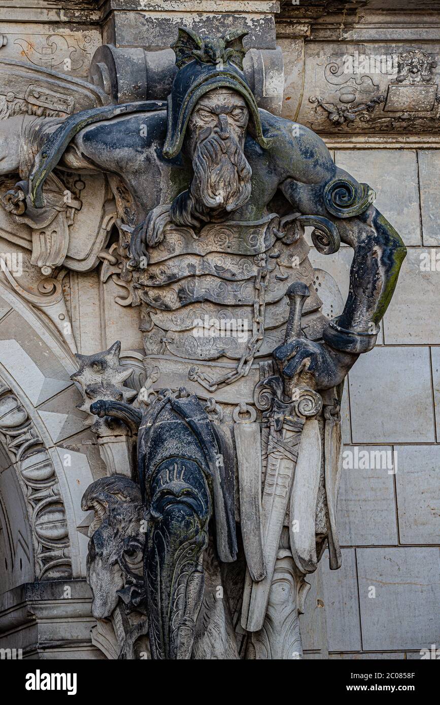 Very old statute of scary gatekeeper, medieval warrior with weapon in ...