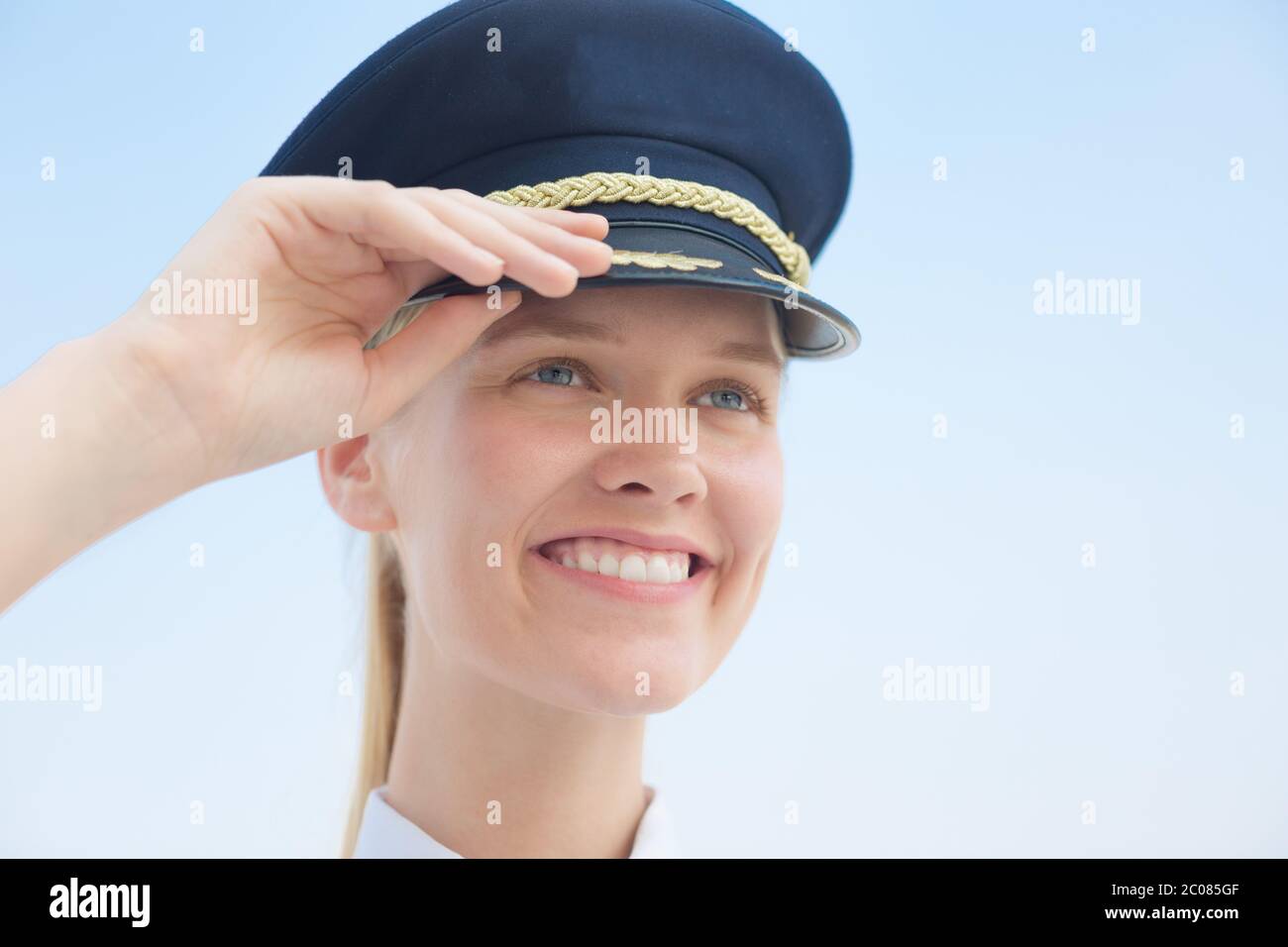 A blonde beautiful pilot woman in her uniform getting ready to fly at ...