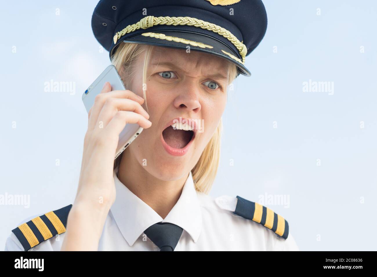A professional pilot with a shocked expression hearing bad news on the ...