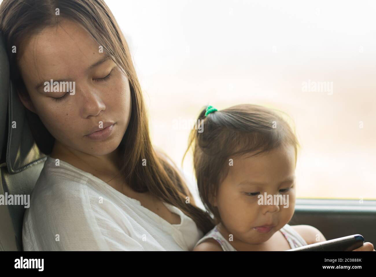 A parent and child sitting on a training taking a break from a busy day ...