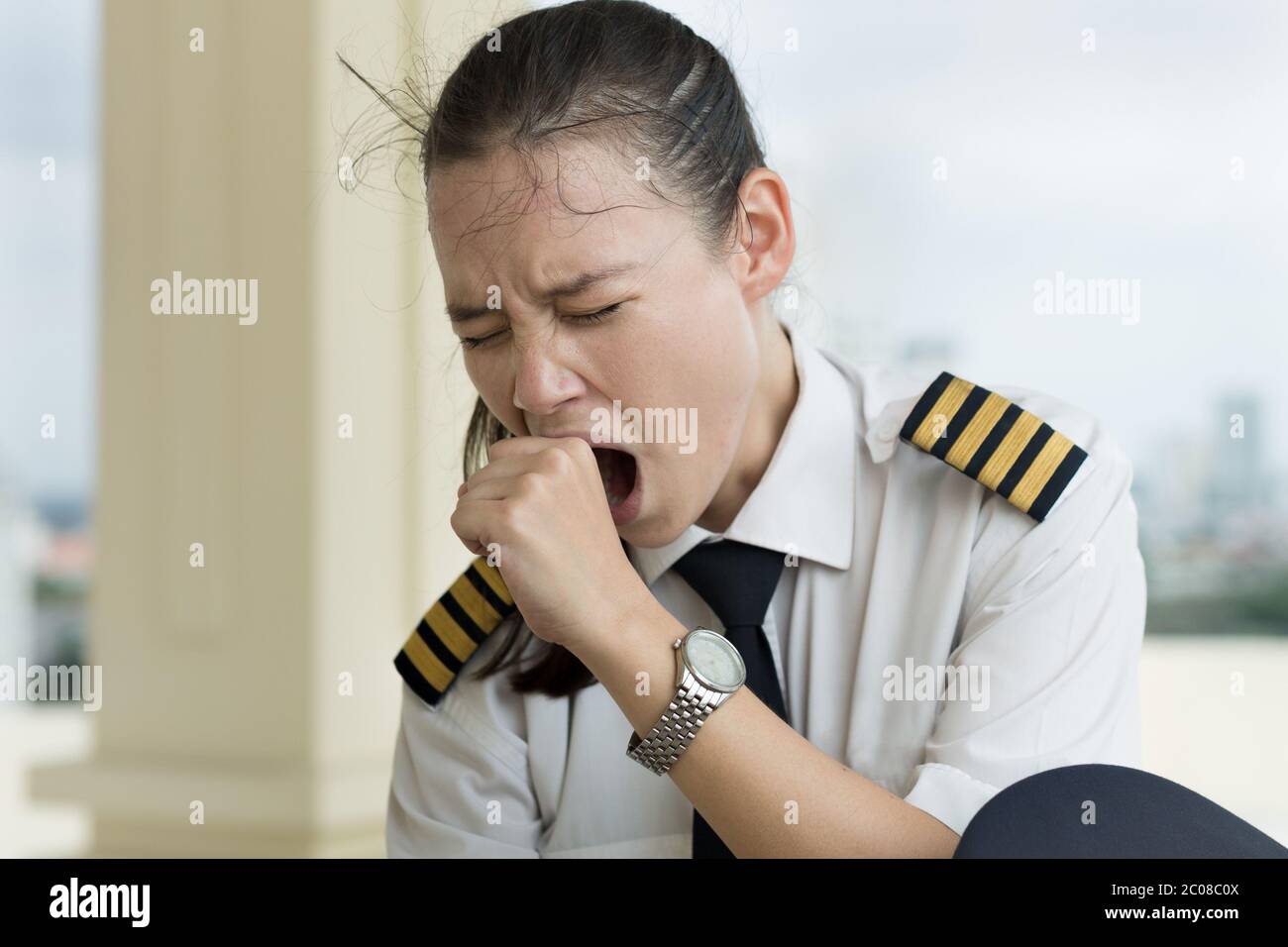 A professional captain pilot drained from flying long hours, sitting at ...