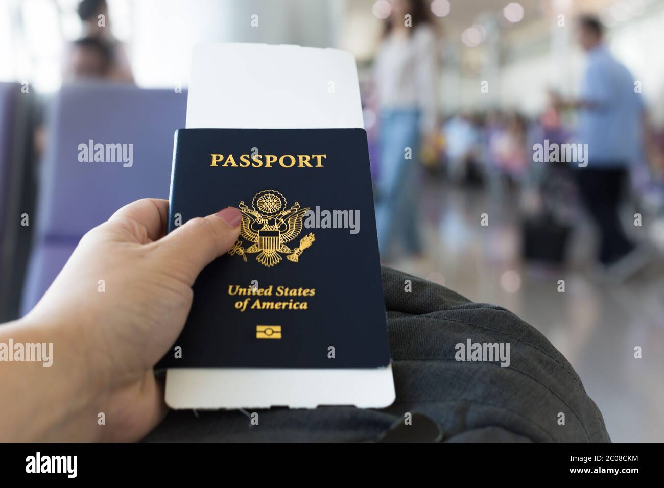 A passenger waitng at the airport boarding gate with her passport and ...