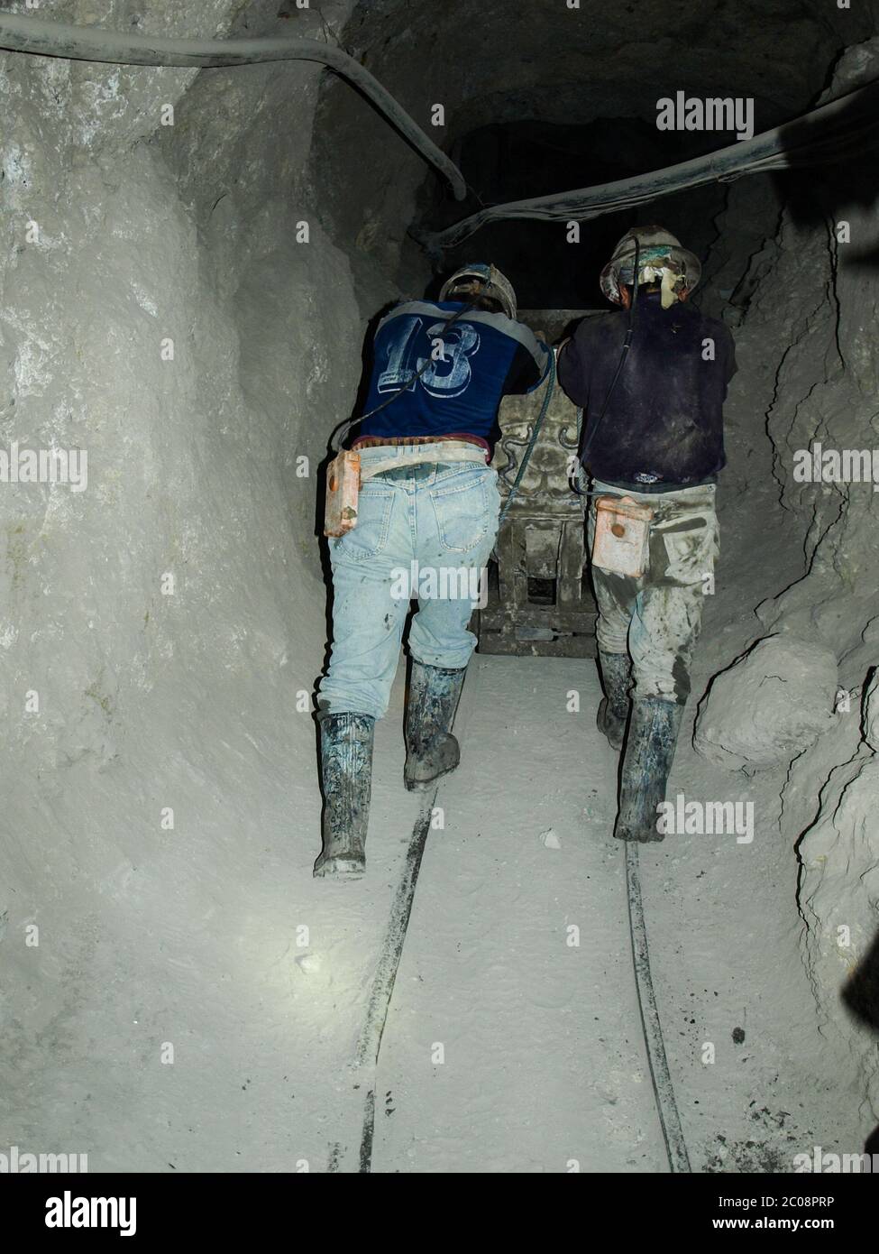 Two miners push the mining truck in Potosi silver mines Stock Photo - Alamy