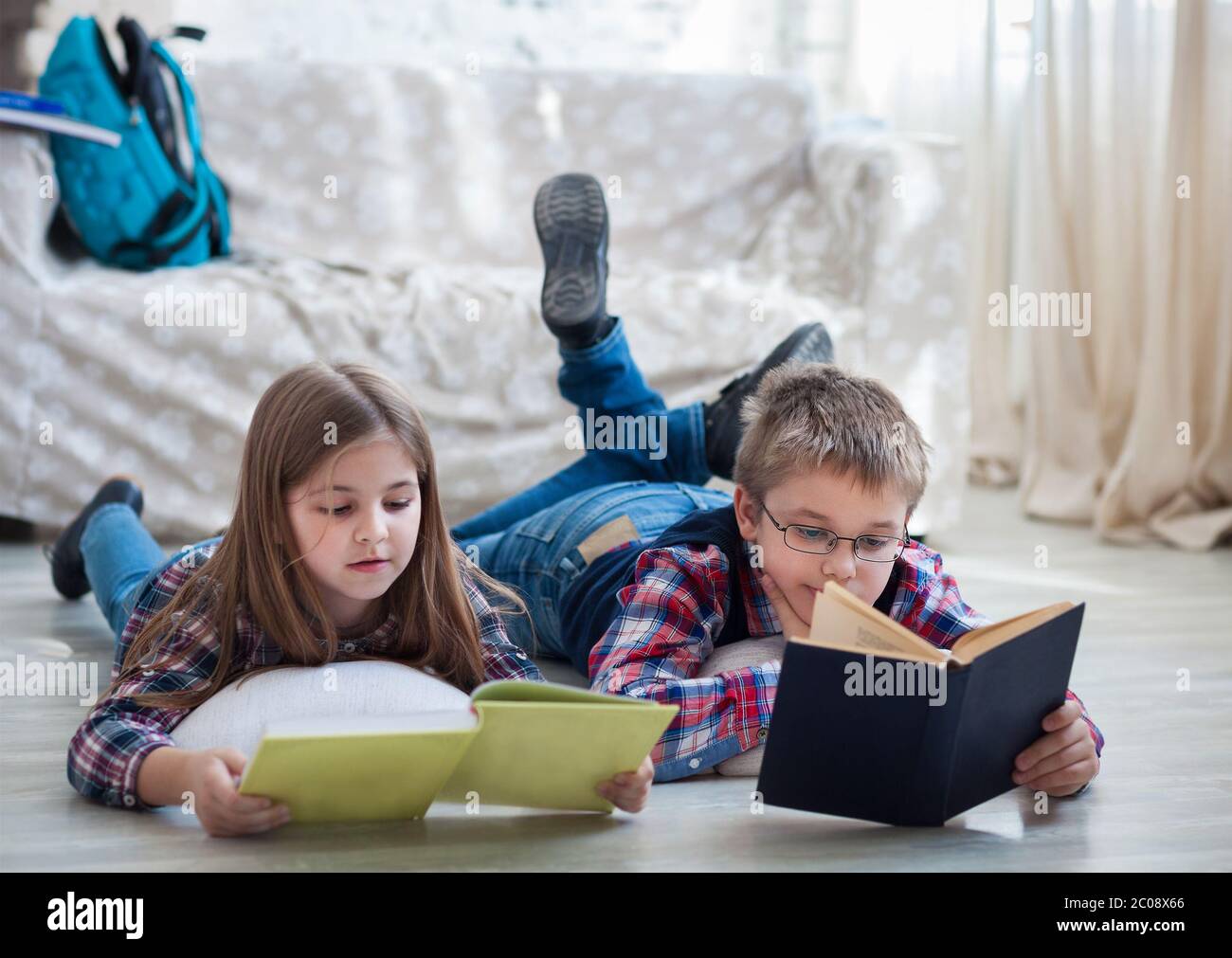 Children readind book in living room Stock Photo - Alamy