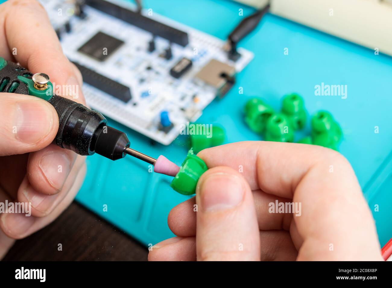 Grinding a small plastic detail close up Stock Photo - Alamy