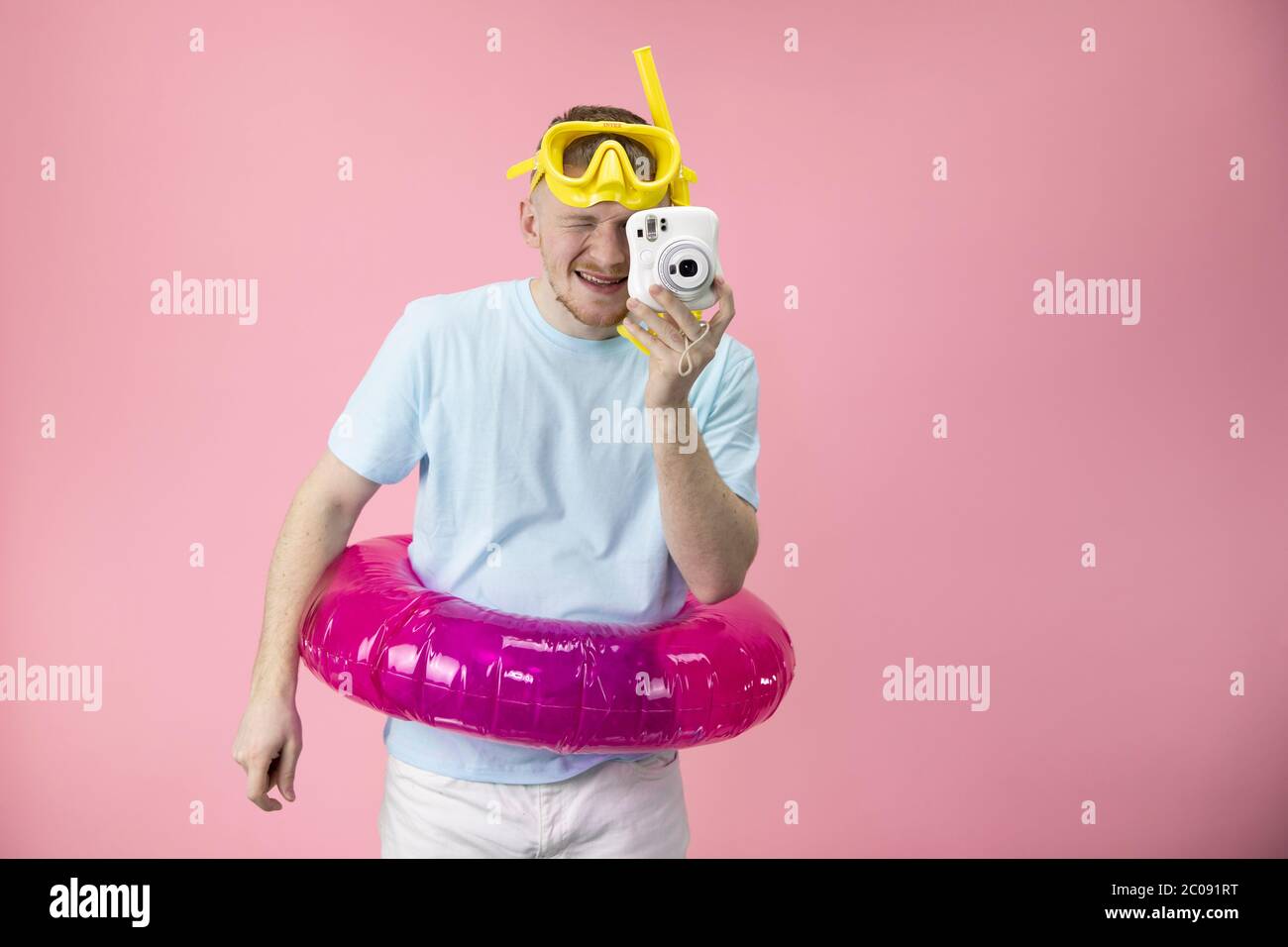 Happy male with yellow swimming mask and with rubber ring make instant ...