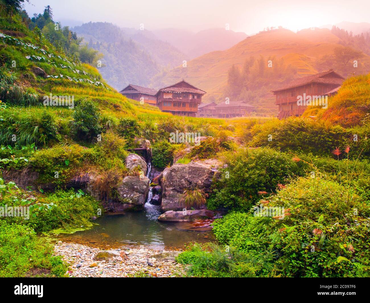 Wooden houses and small waterfall on Dragon's Backbone Rice Terraces ...