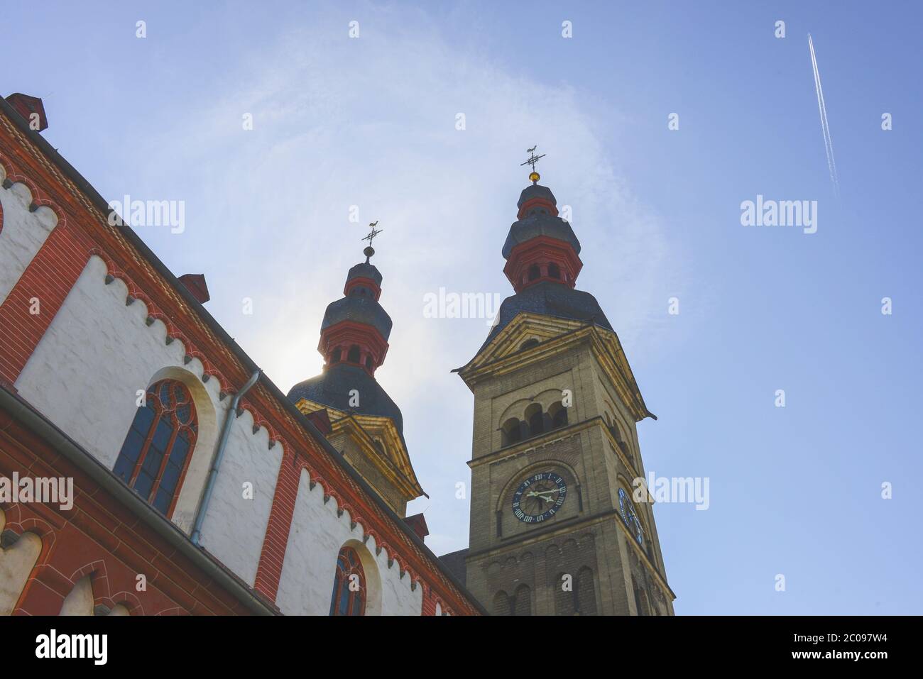 Blue sky with airplane trail and the front of cathedral in Gothic ...