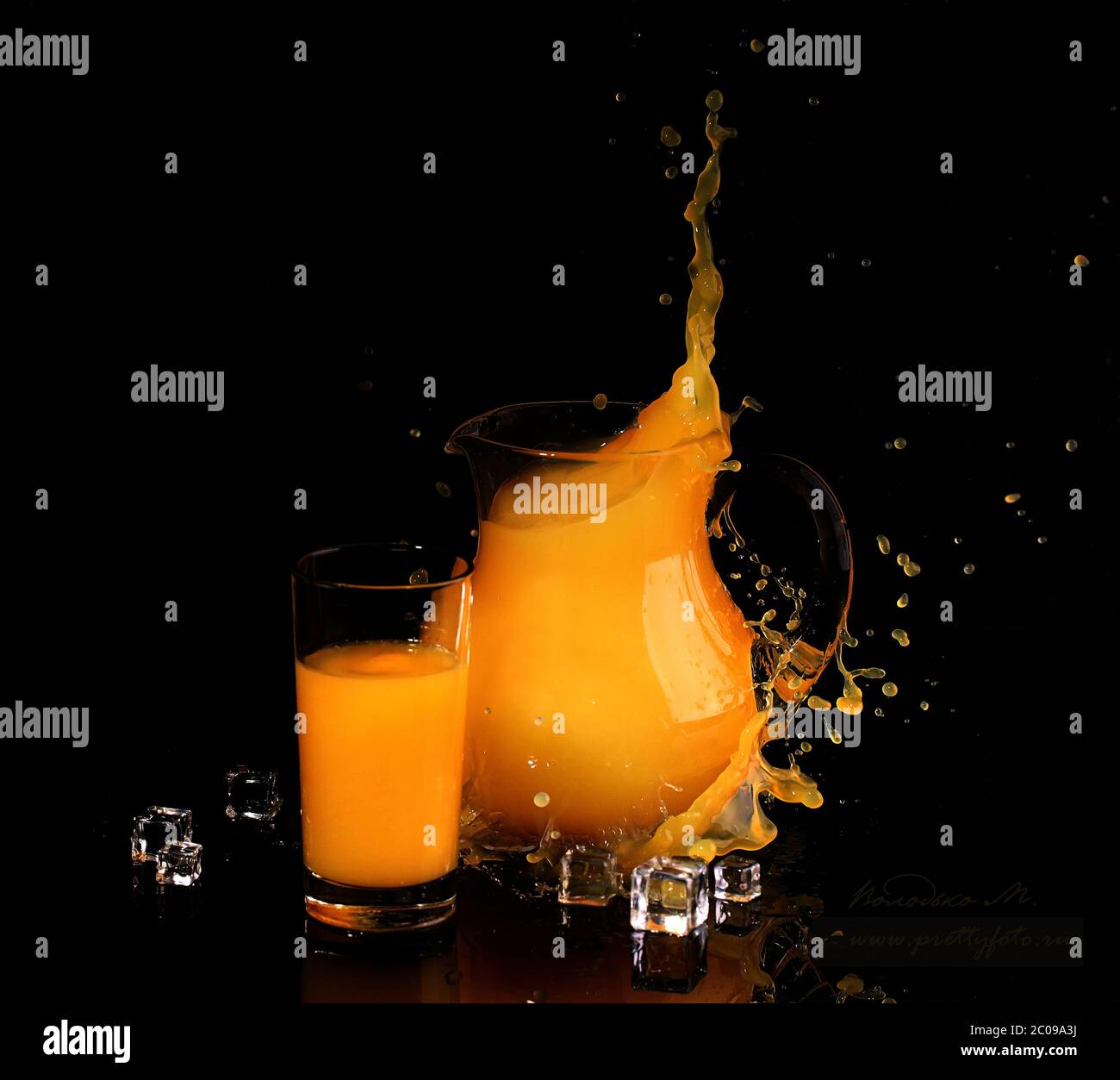 Splash in orange juice in a transparent jug on a black background Stock ...