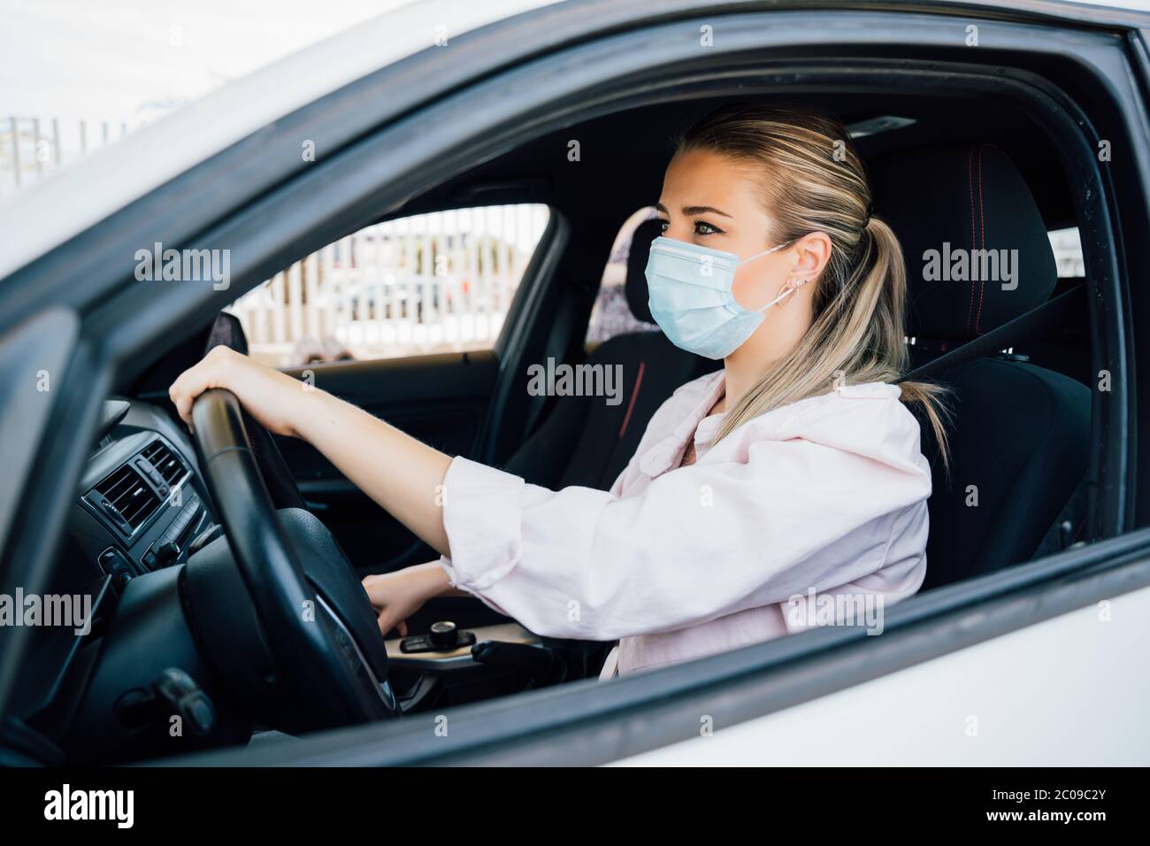 Woman with face mask driving her car during coronavirus pandemic Stock ...
