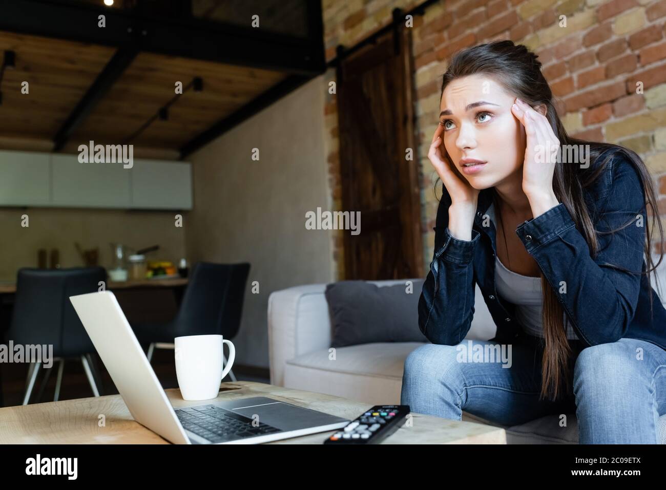 selective focus of concentrated girl touching head while watching movie ...