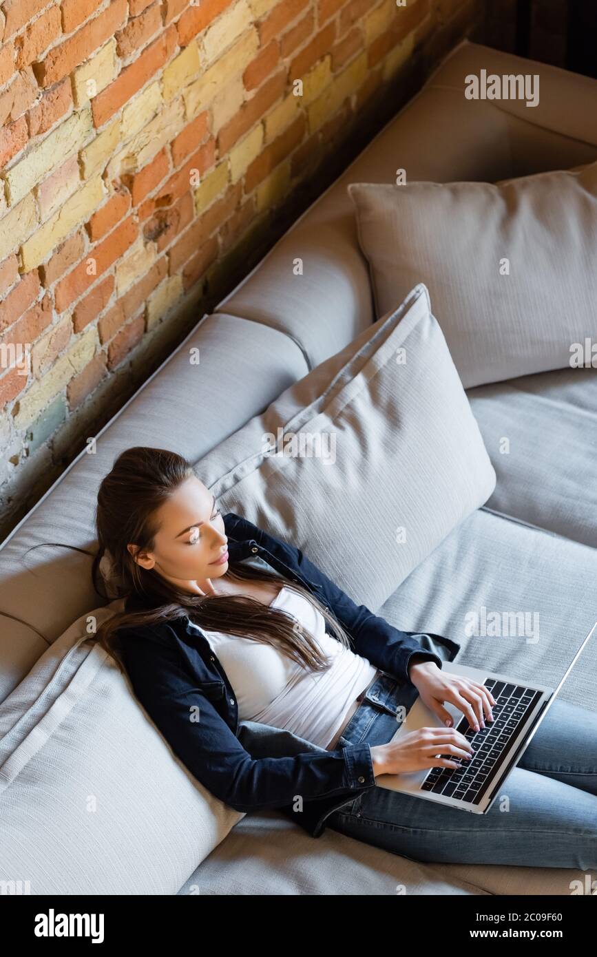 overhead view of attractive freelancer typing on laptop keyboard at ...