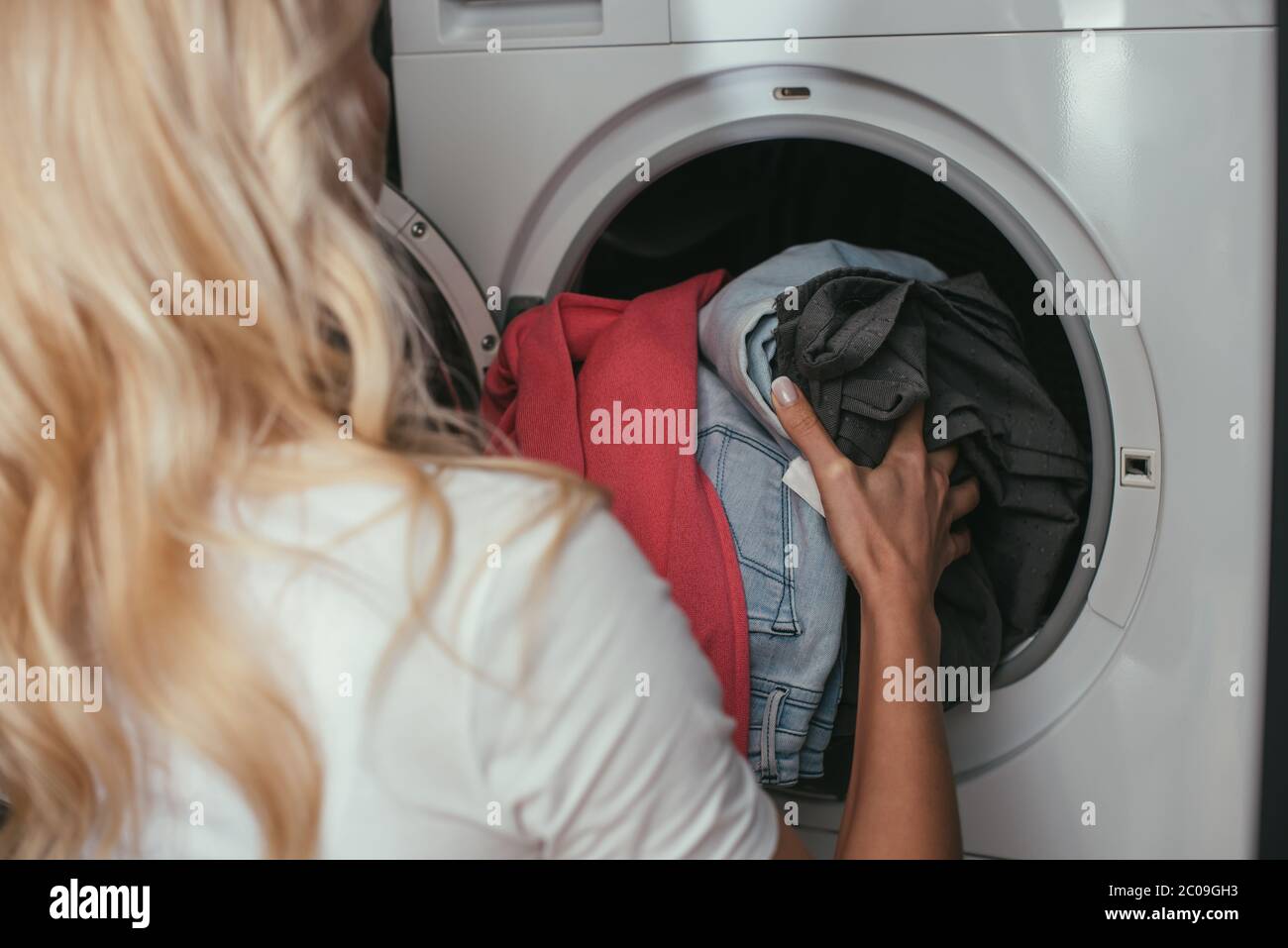 back view of housewife putting laundry into washing machine Stock Photo ...