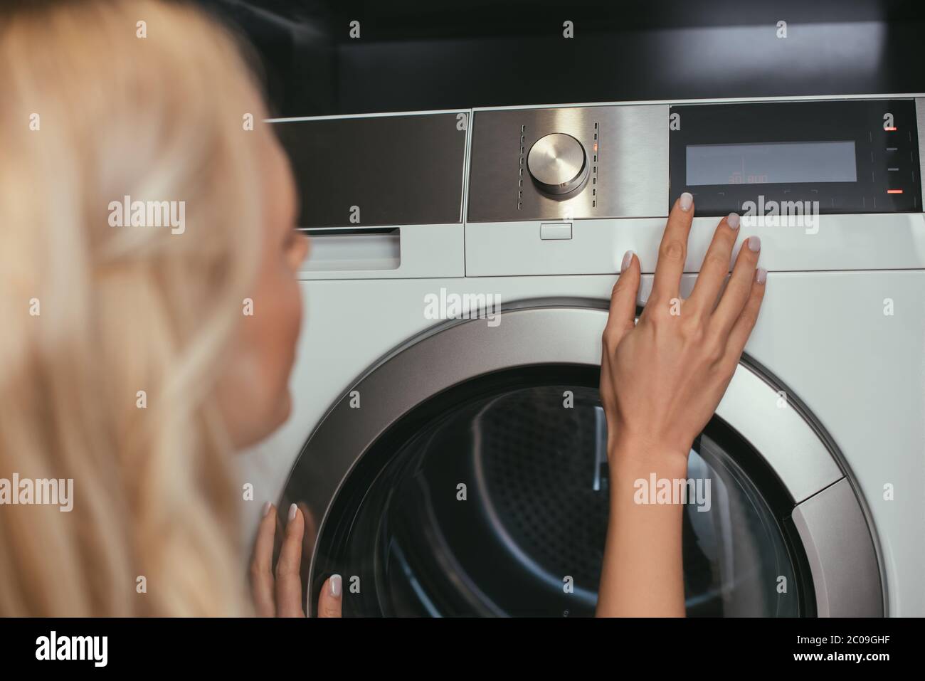 back view of housewife touching control panel of washing machine Stock ...