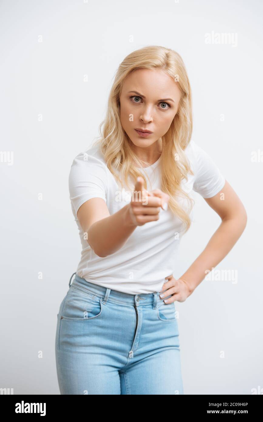 angry blonde girl pointing with finger at camera isolated on white ...
