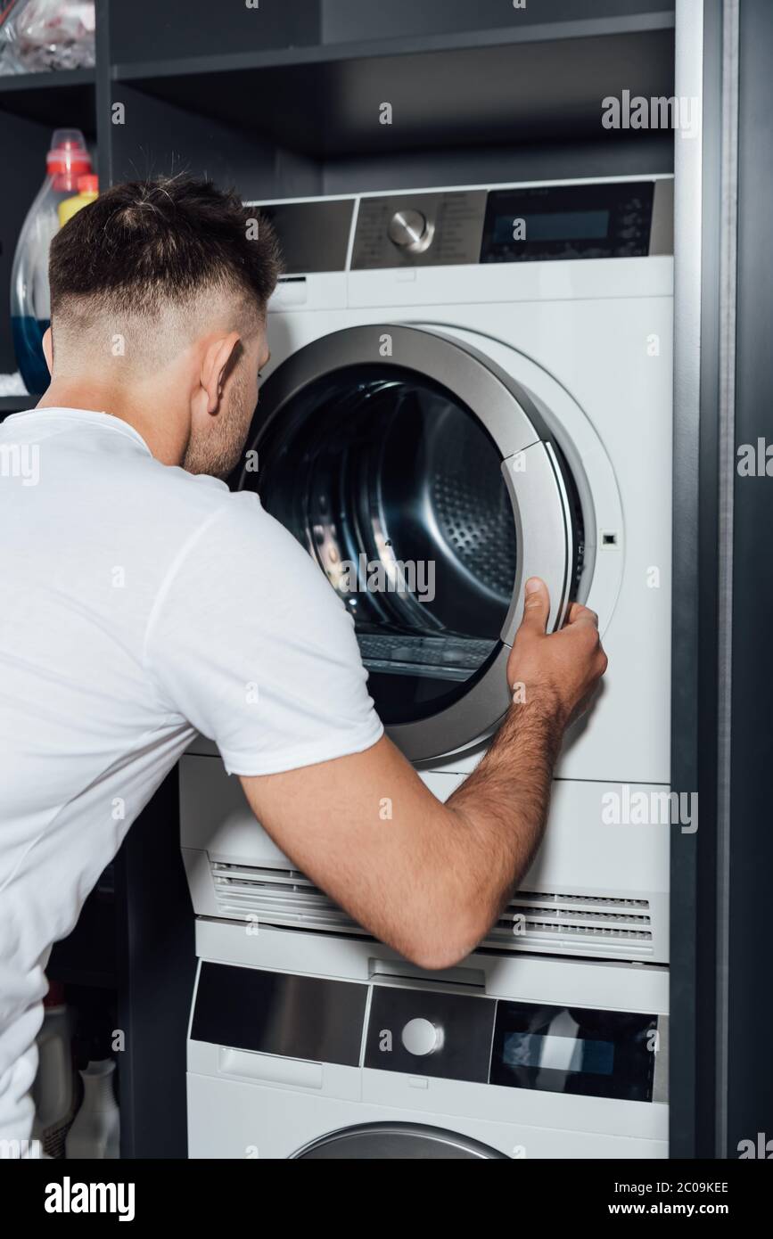 man opening door of modern washing machine at home Stock Photo - Alamy