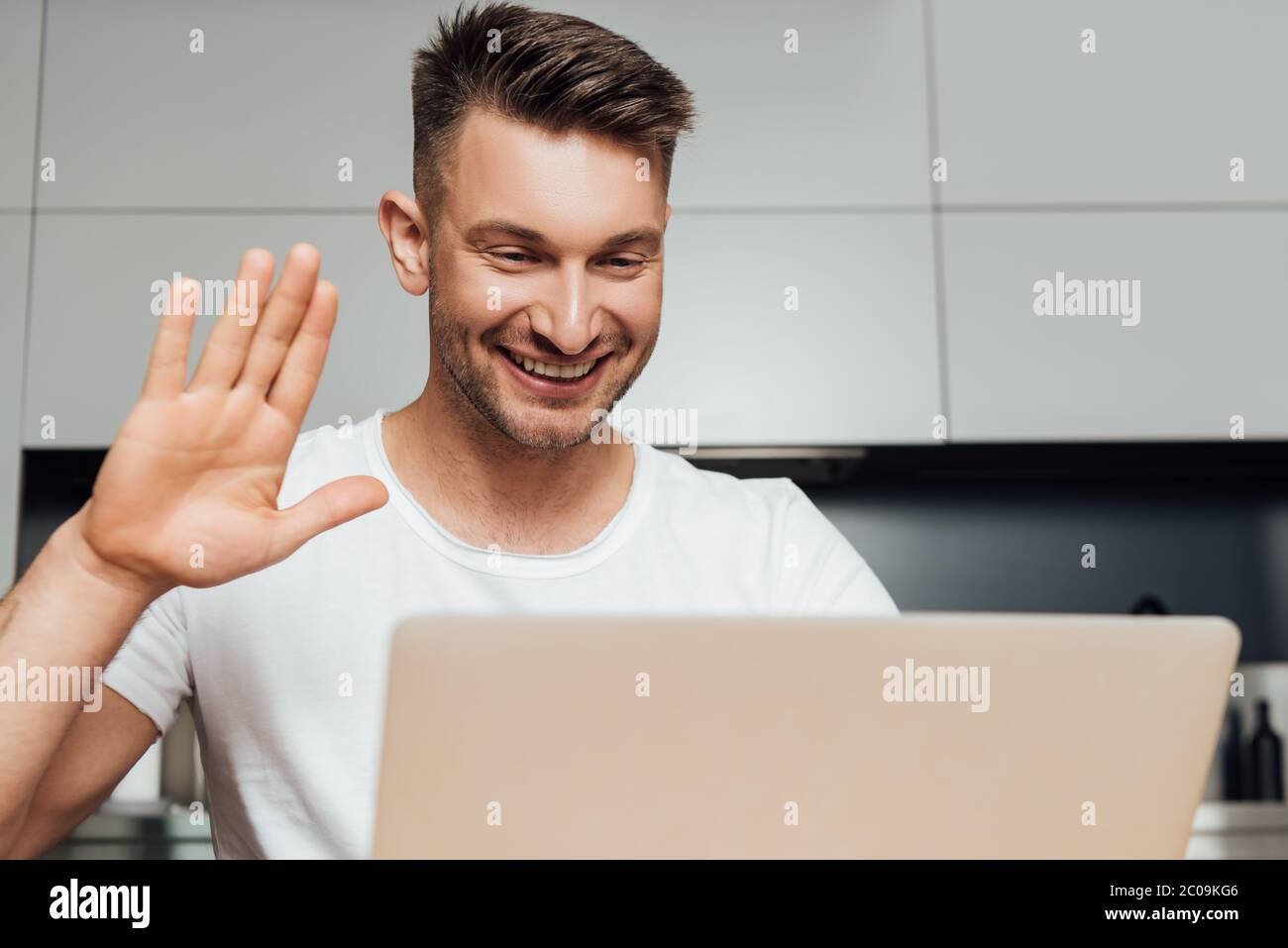 selective focus of happy man waving hand and having video call Stock ...