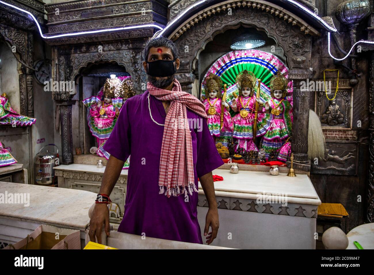 Indian Hindu Pandits (priests) standing next to indian god idols after ...