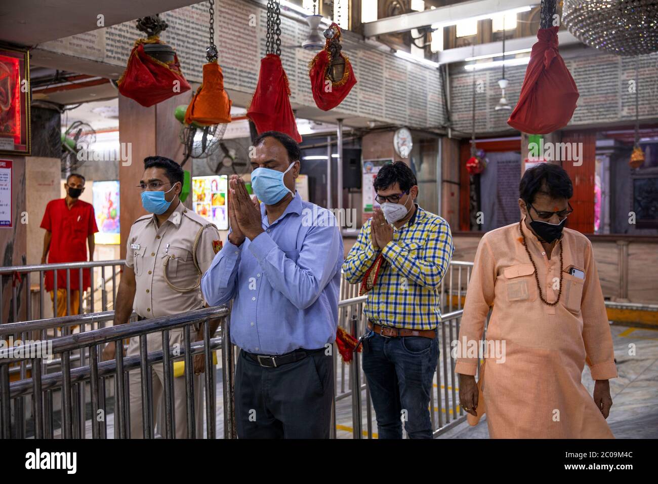 A group of indian man offering prayer inside a temple after the opening ...