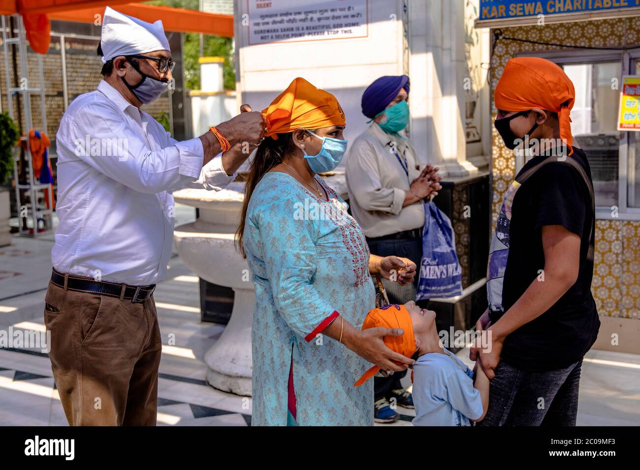 A indian family wearing headgear before entering Bangla Sahib Gurudwara ...