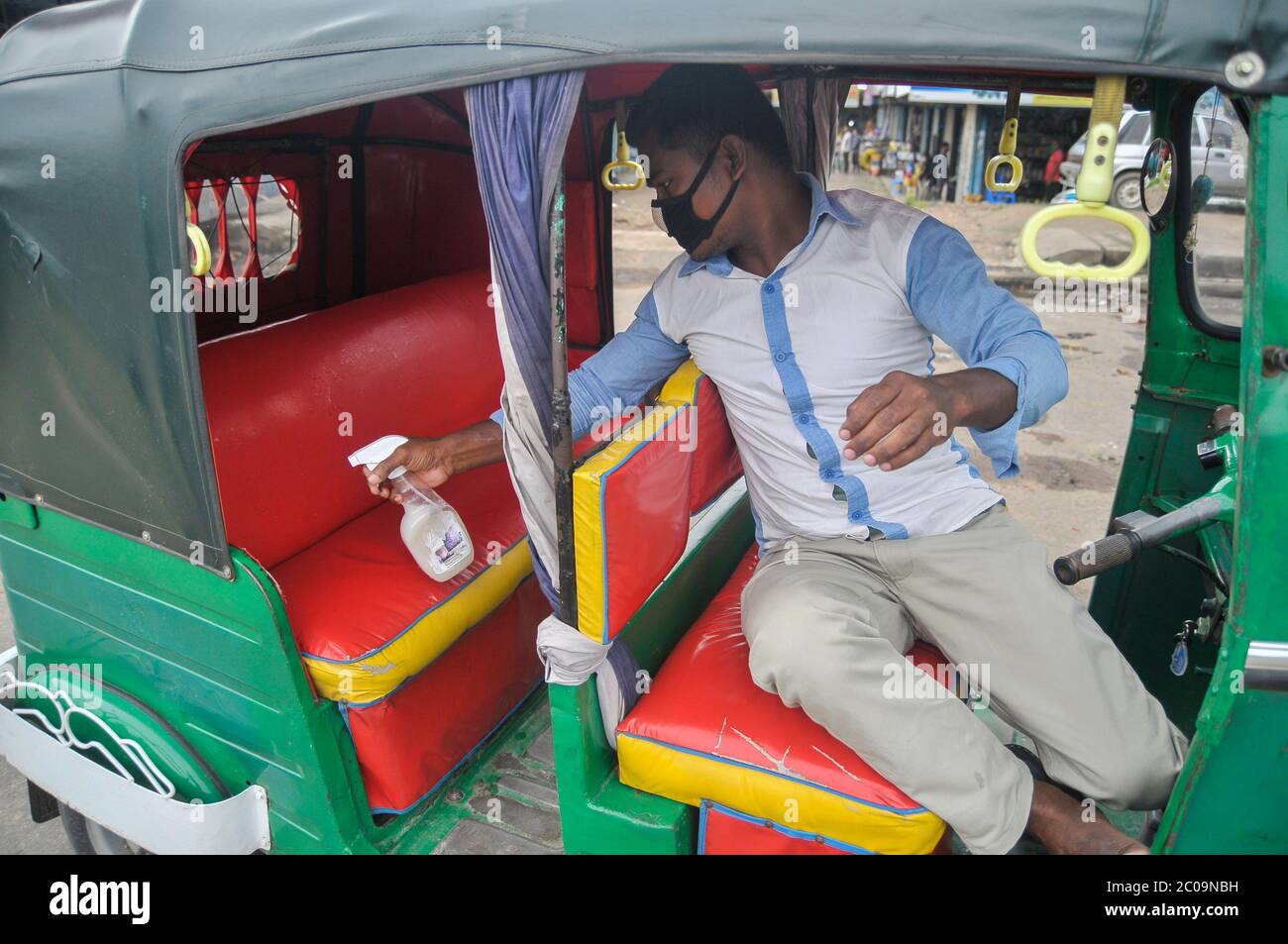 A CNG driver spaying sanitizar for his passengers as preventive ...