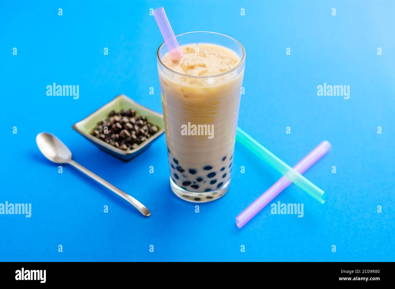 A glass of homemade milk tea bubbletea, with ice and tapioca balls ...