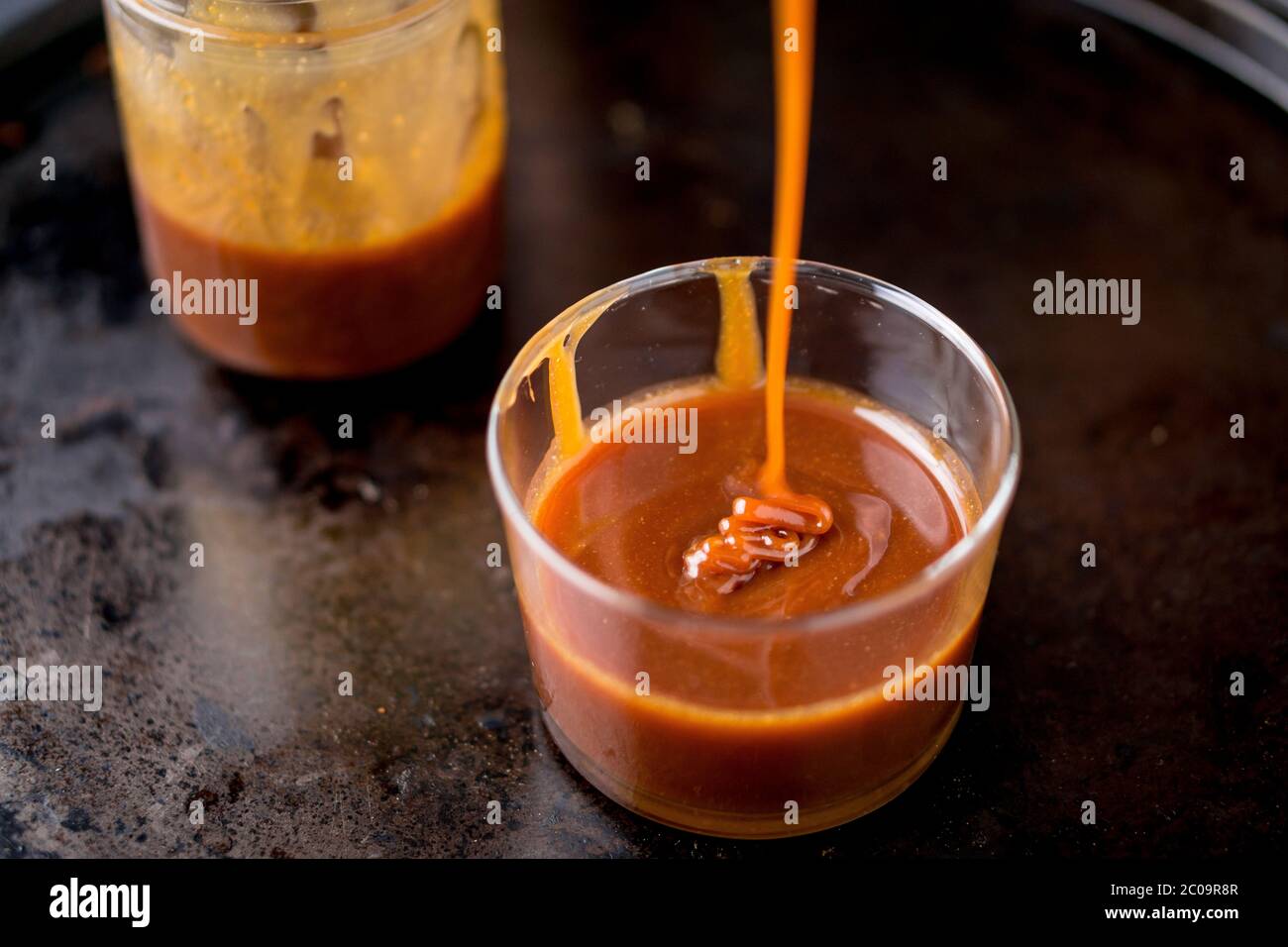 Caramel sauce dripping in a jar. This sweet and delicious caramel sauce ...