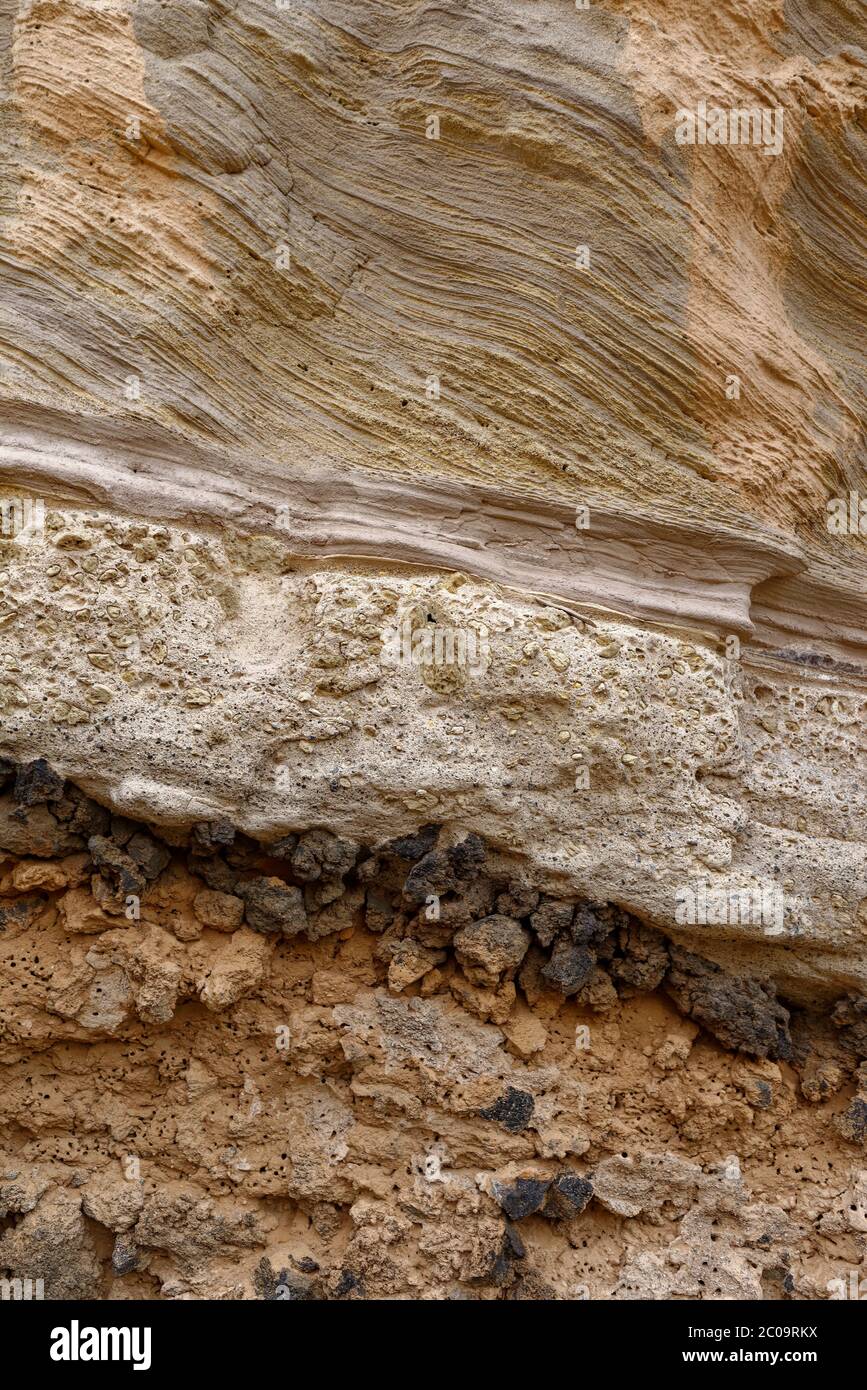 Volcanic Ash, Brecia and Lava Flow layers on a rock face within a small Valley one the Island of ...