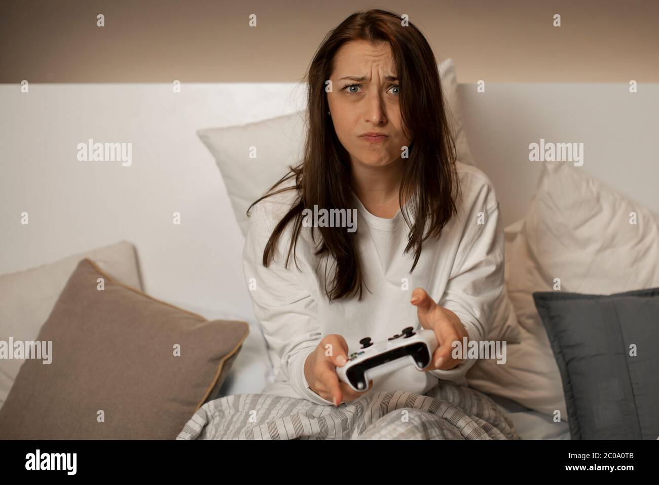 Cute girl with dark hair in bedroom plays video games on console using ...