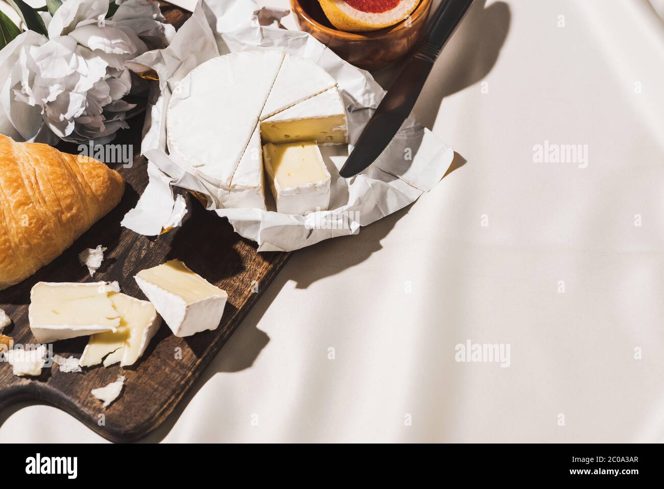 top view of french breakfast with croissant, Camembert, peony on wooden ...