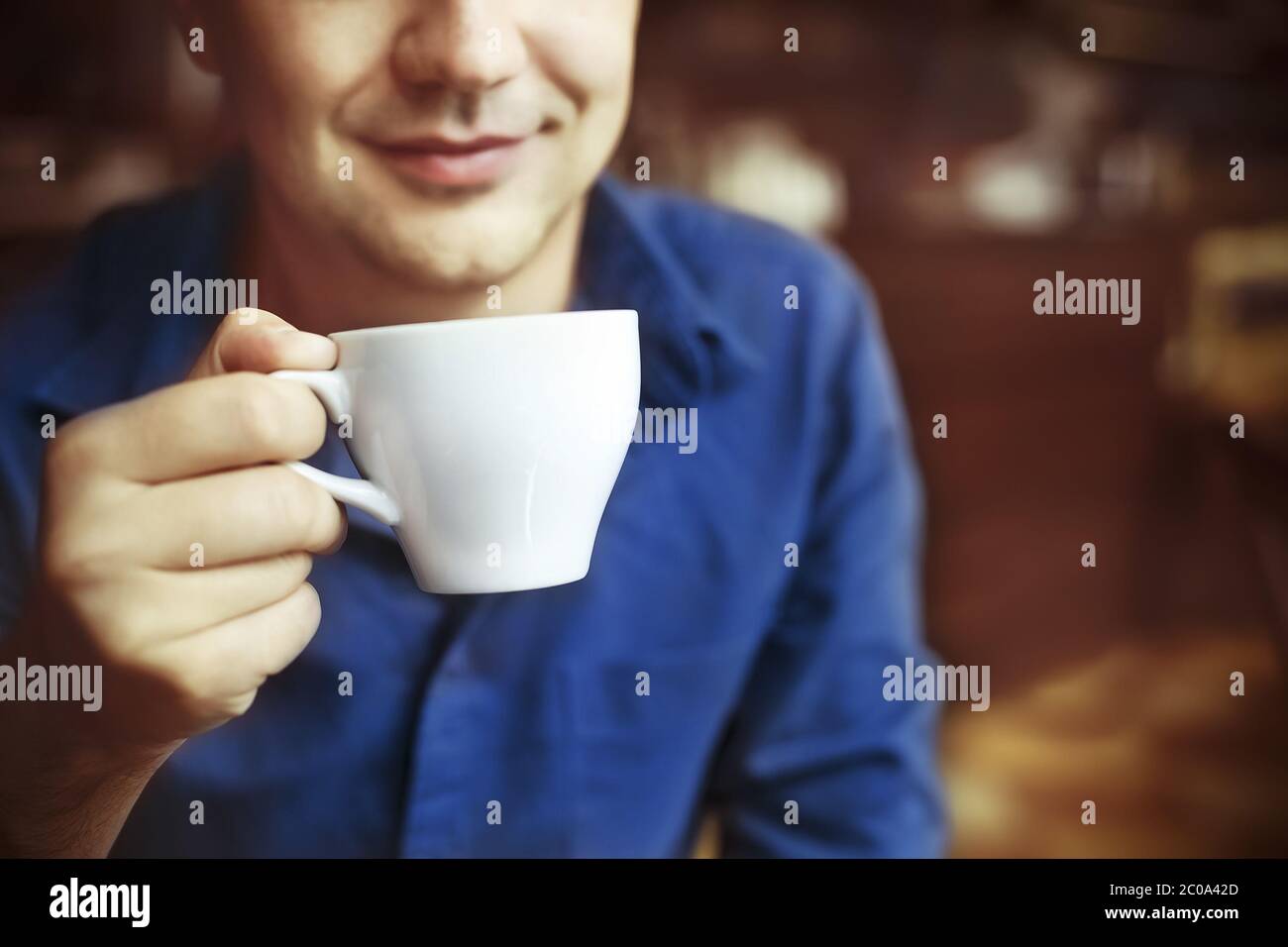 Man drinking white tea cup in cafe Stock Photo - Alamy