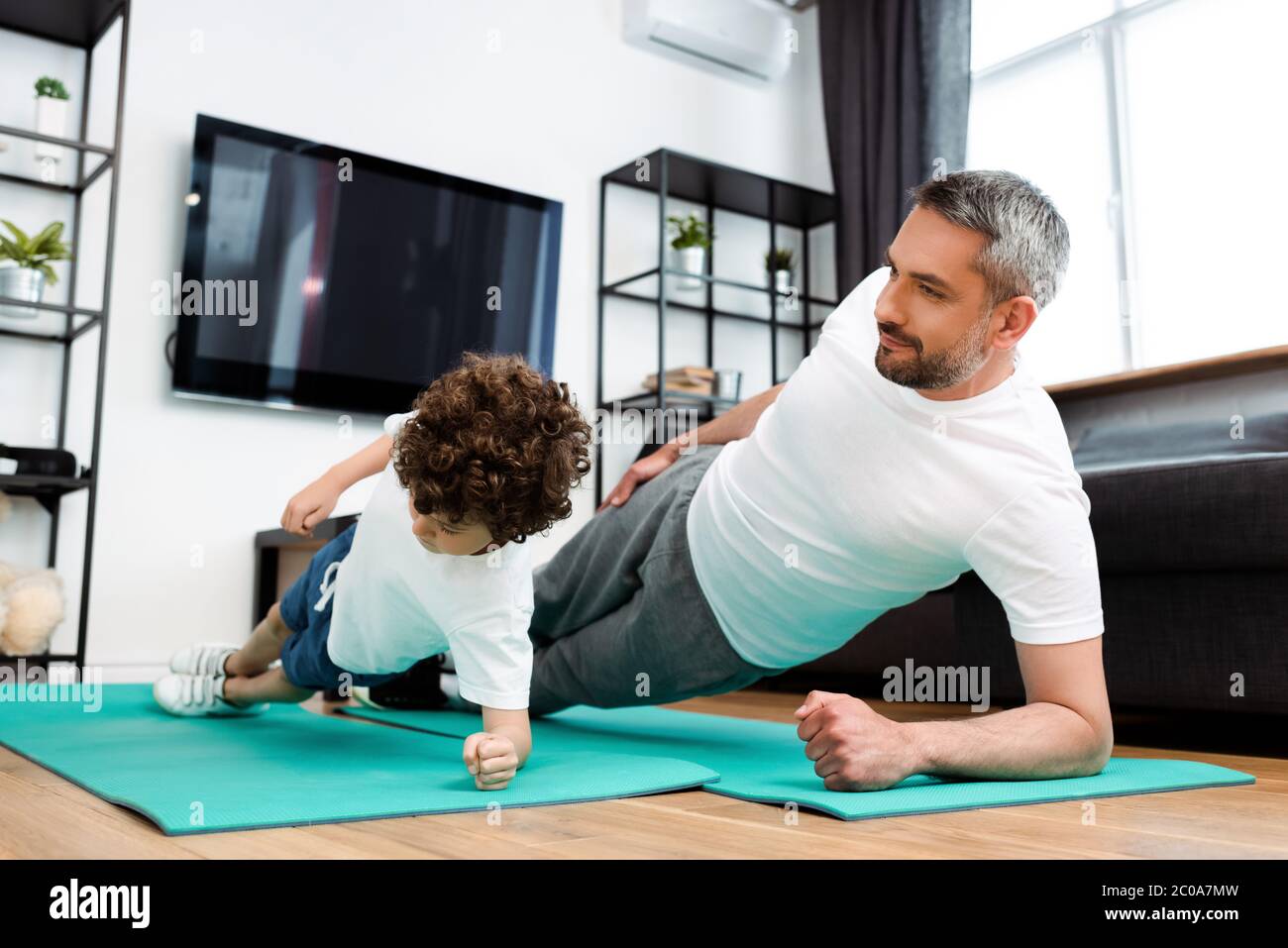 handsome father and cute son exercising on fitness mats Stock Photo - Alamy