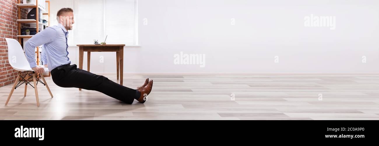 Office Exercise Using Chair. Man Workout At Desk Stock Photo - Alamy