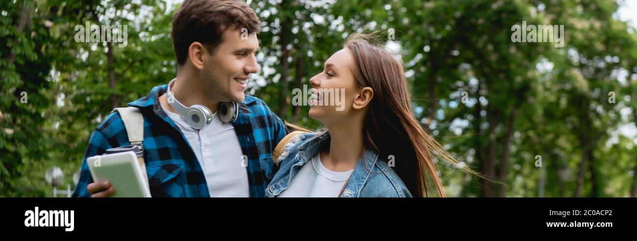 horizontal image of cheerful and young students looking at each other ...