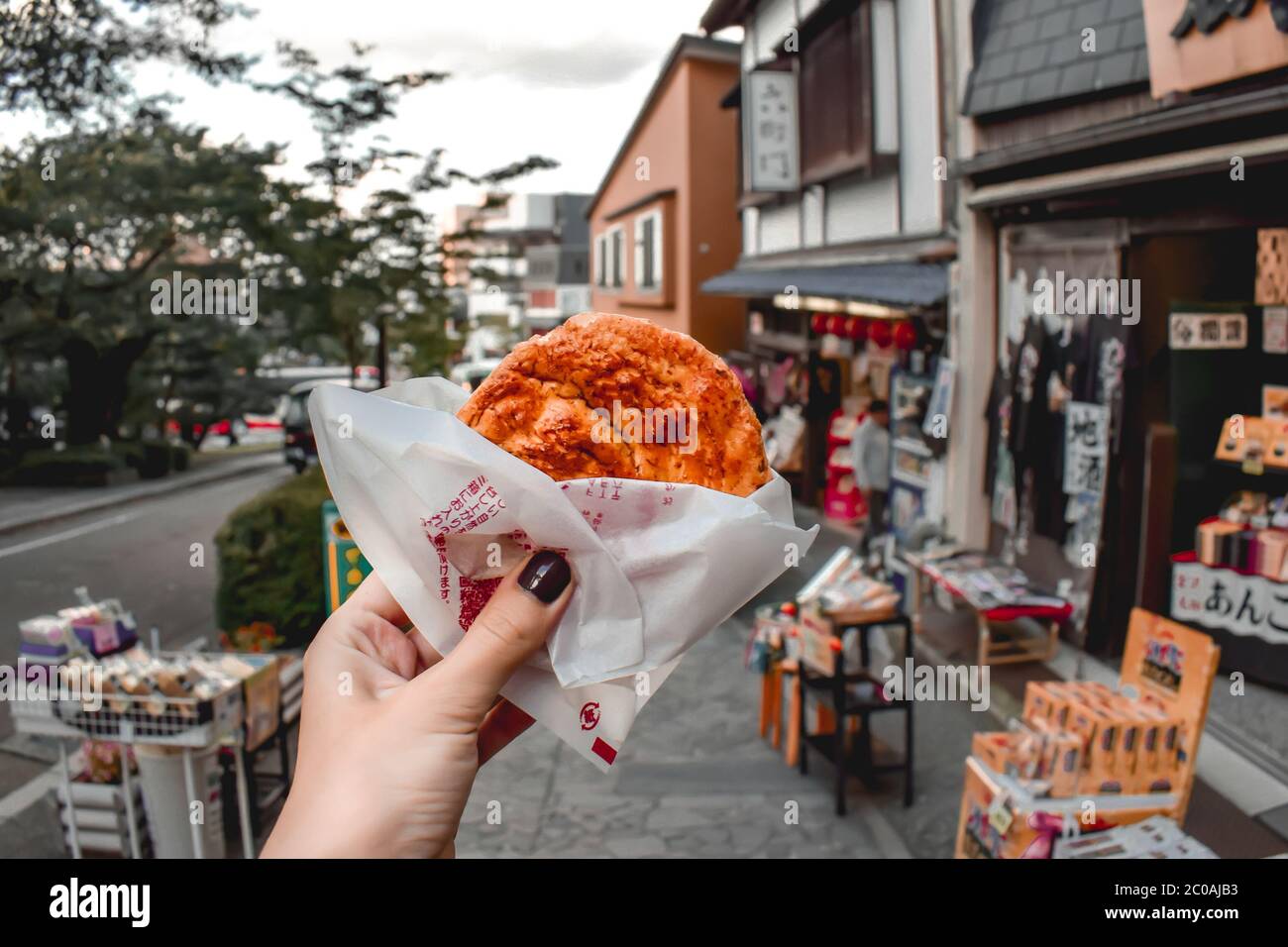 Female hand holding a traditional Japanese street food spicy corn ...