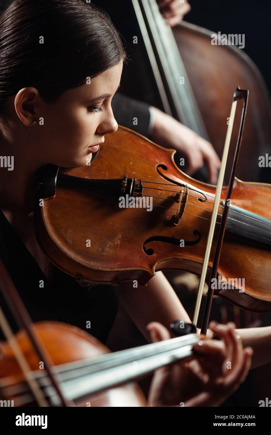 professional musicians playing classical music on dark stage Stock ...