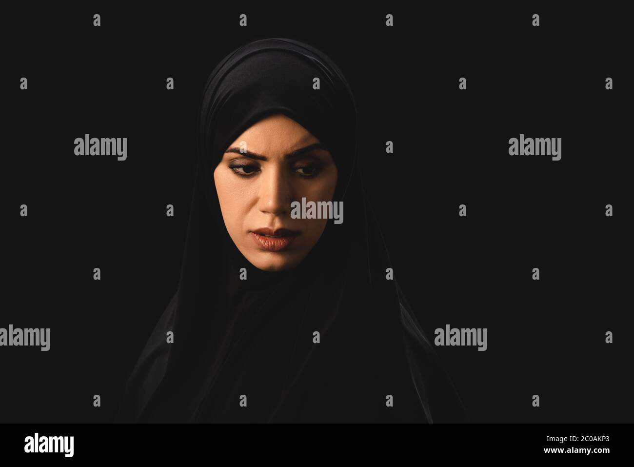 Sad muslim woman looking away isolated on black Stock Photo - Alamy