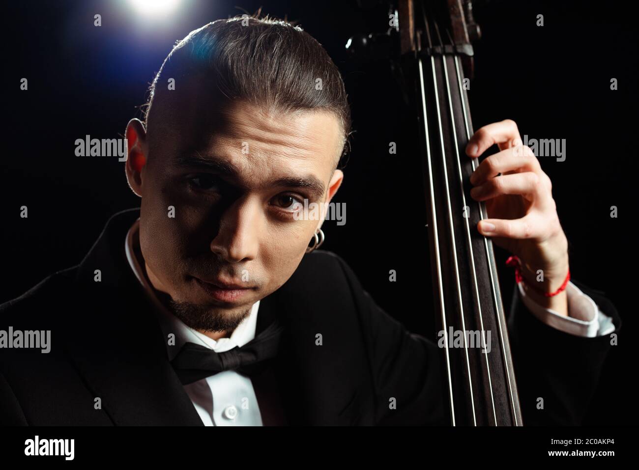 professional musician playing on double bass on dark stage Stock Photo ...