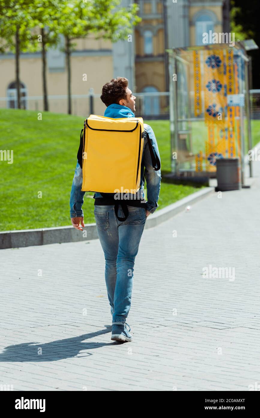 Back view of courier with thermo backpack walking on urban street Stock ...