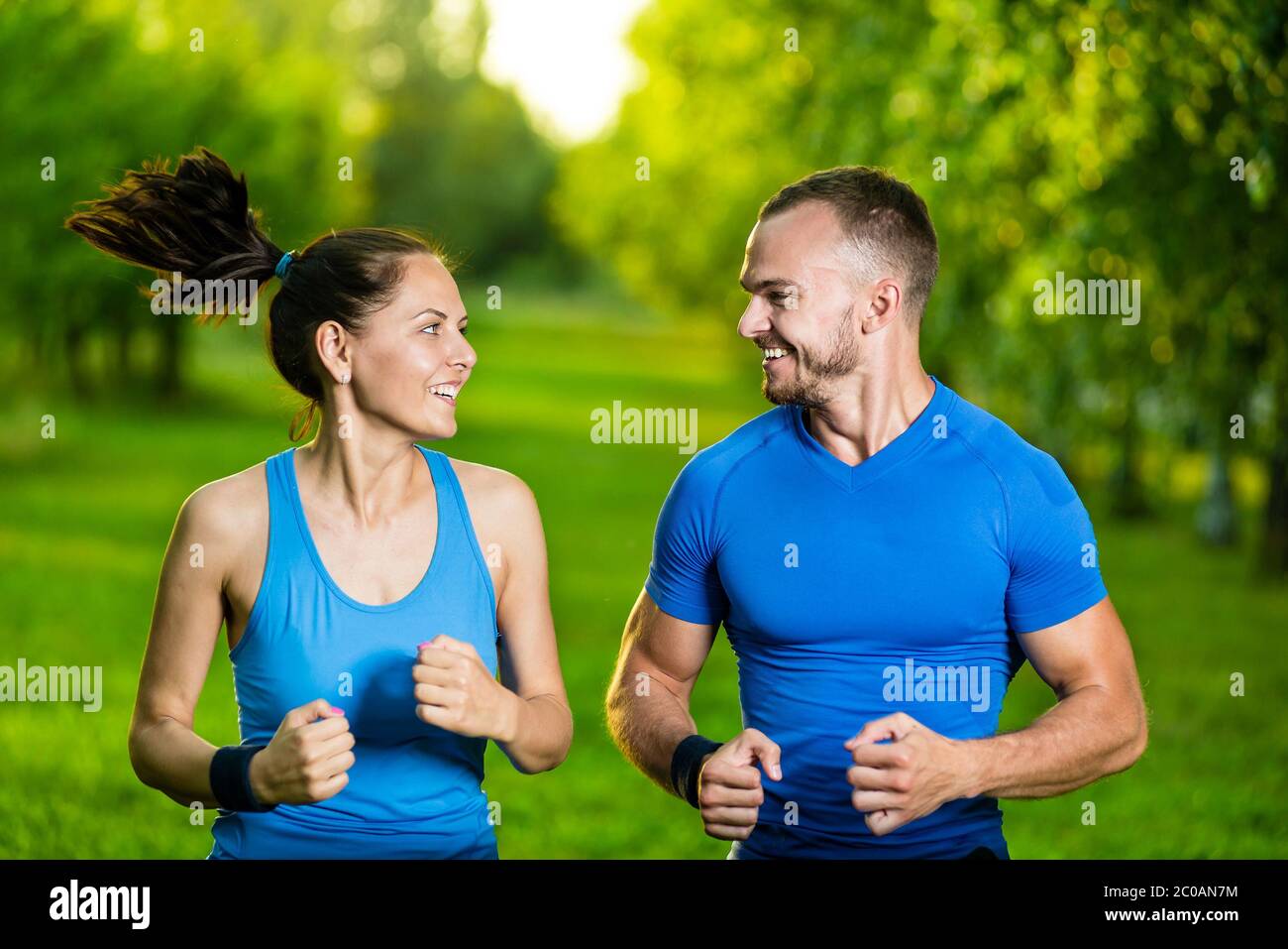 Runners training outdoors working out. City running couple jogging ...