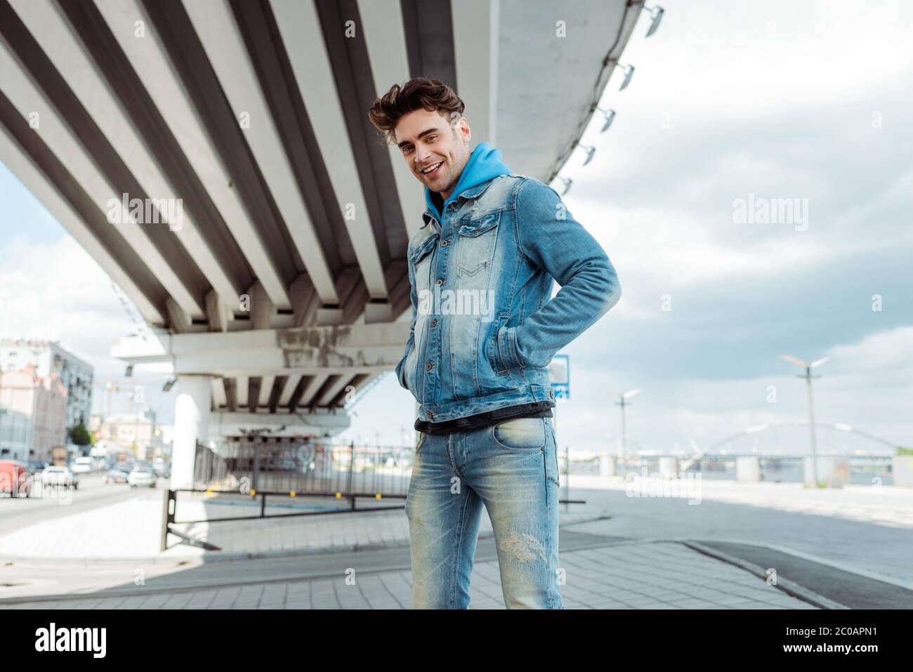 Low angle view of handsome man smiling at camera while standing under ...