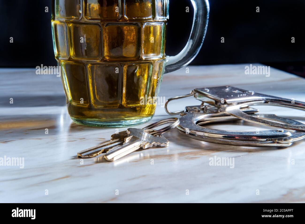 Mug of beer with handcuffs and keys symbolizing drunk driving arrest ...