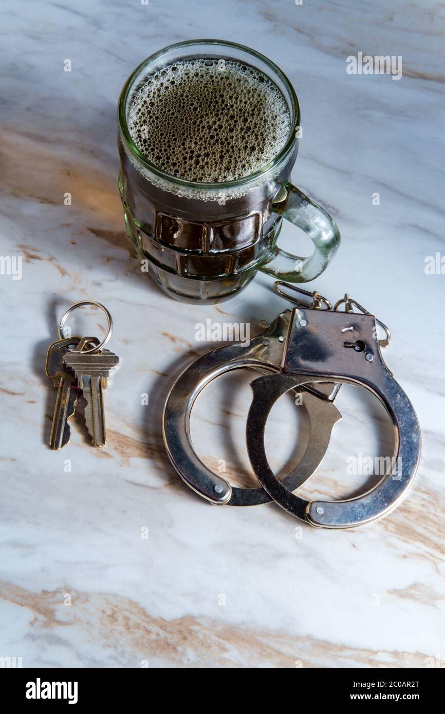 Mug of beer with handcuffs and keys symbolizing drunk driving arrest ...