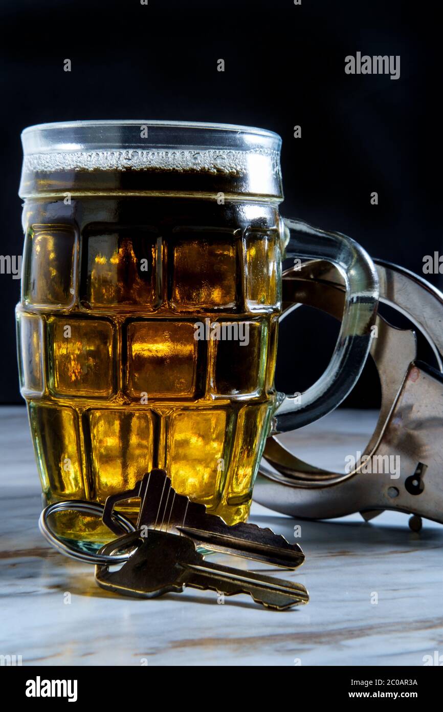 Mug of beer with handcuffs and keys symbolizing drunk driving arrest ...