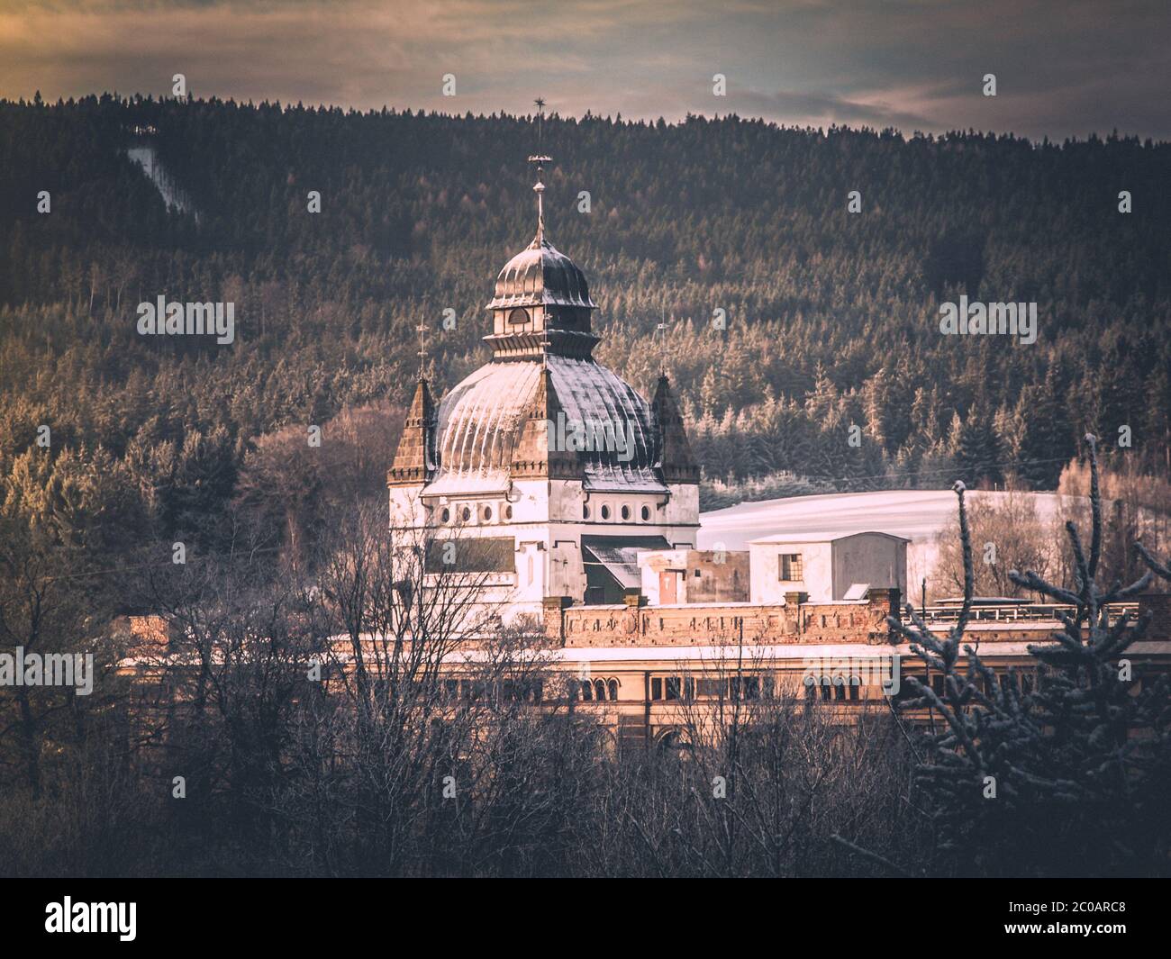Old mountain factory with ornamental dome in winter landscape. Vintage ...