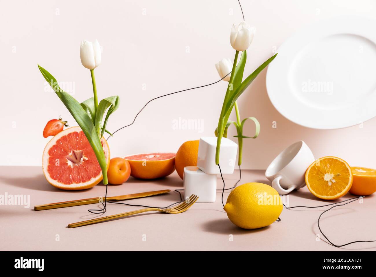 floral and fruit composition with tulips, fruits, dishware isolated on ...